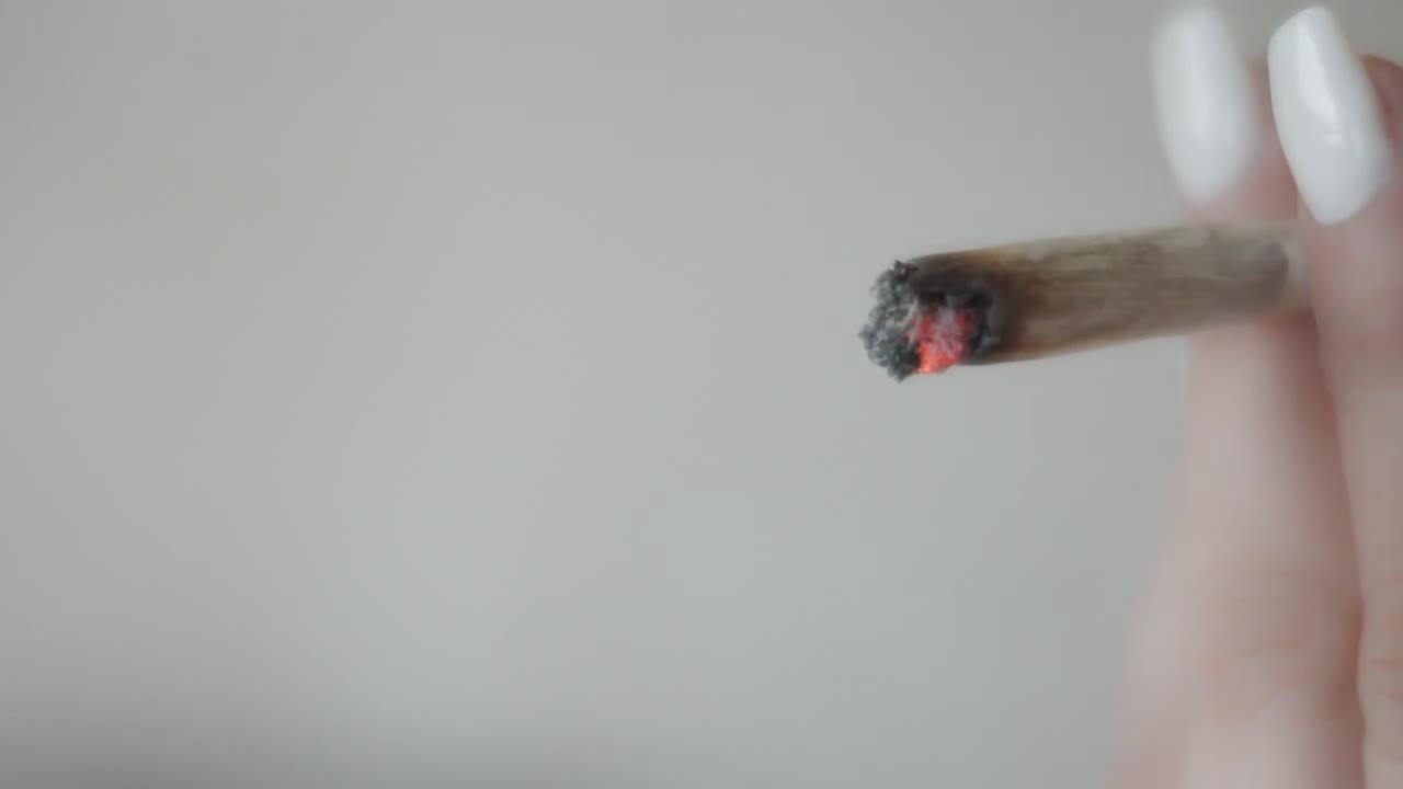 A Woman Smoking A Cannabis Joint,... - Stock Video | Motion Array