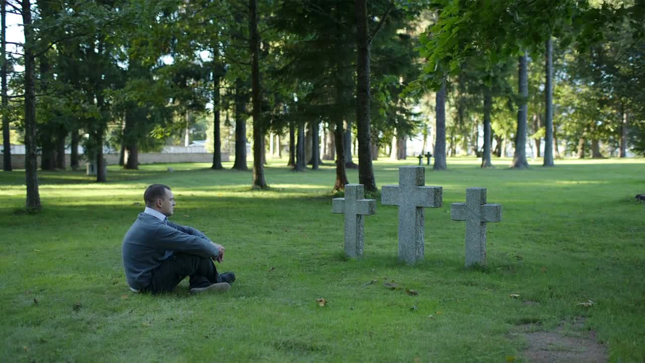 Man Sitting In A Cemetery - Stock Video | Motion Array