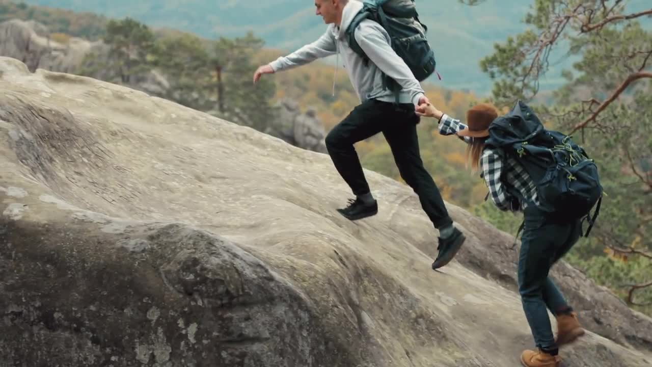 Man Helps His Friend To Climb A Rock - Stock Video | Motion Array