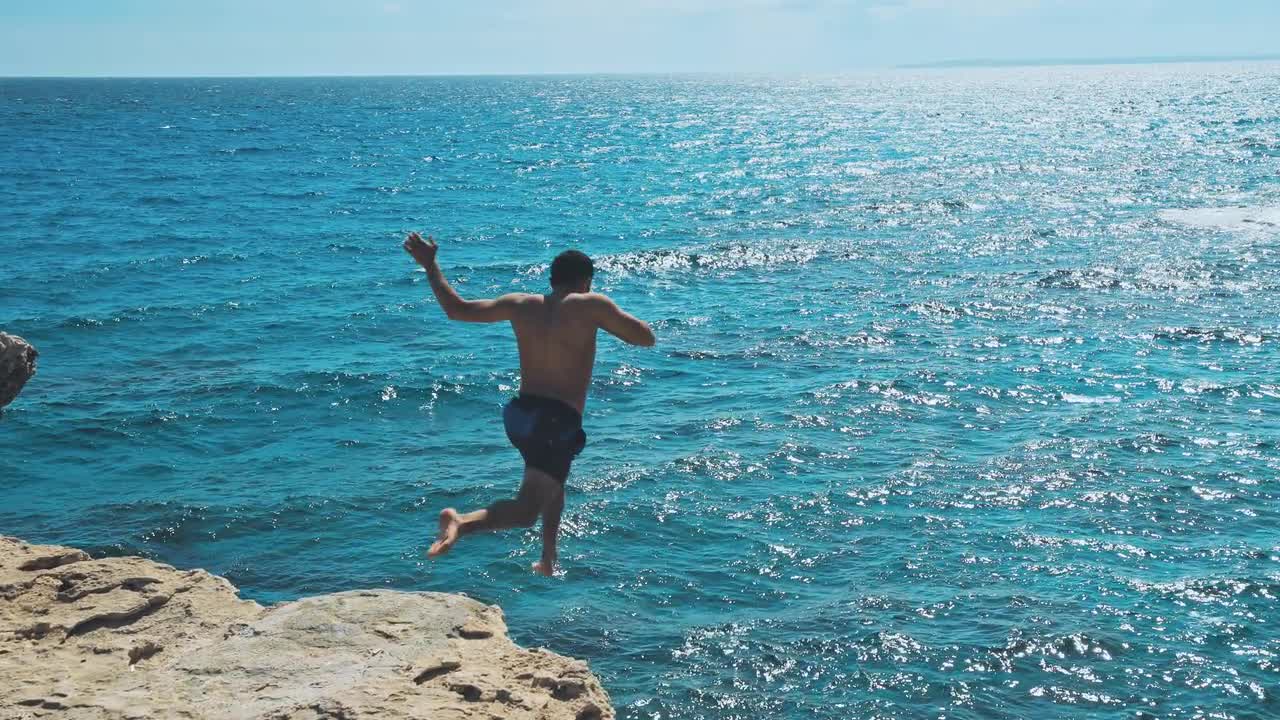 Man Jumping Off Cliff - Stock Video | Motion Array
