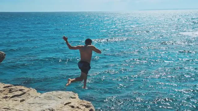 Man Jumping Off Cliff - Stock Video | Motion Array