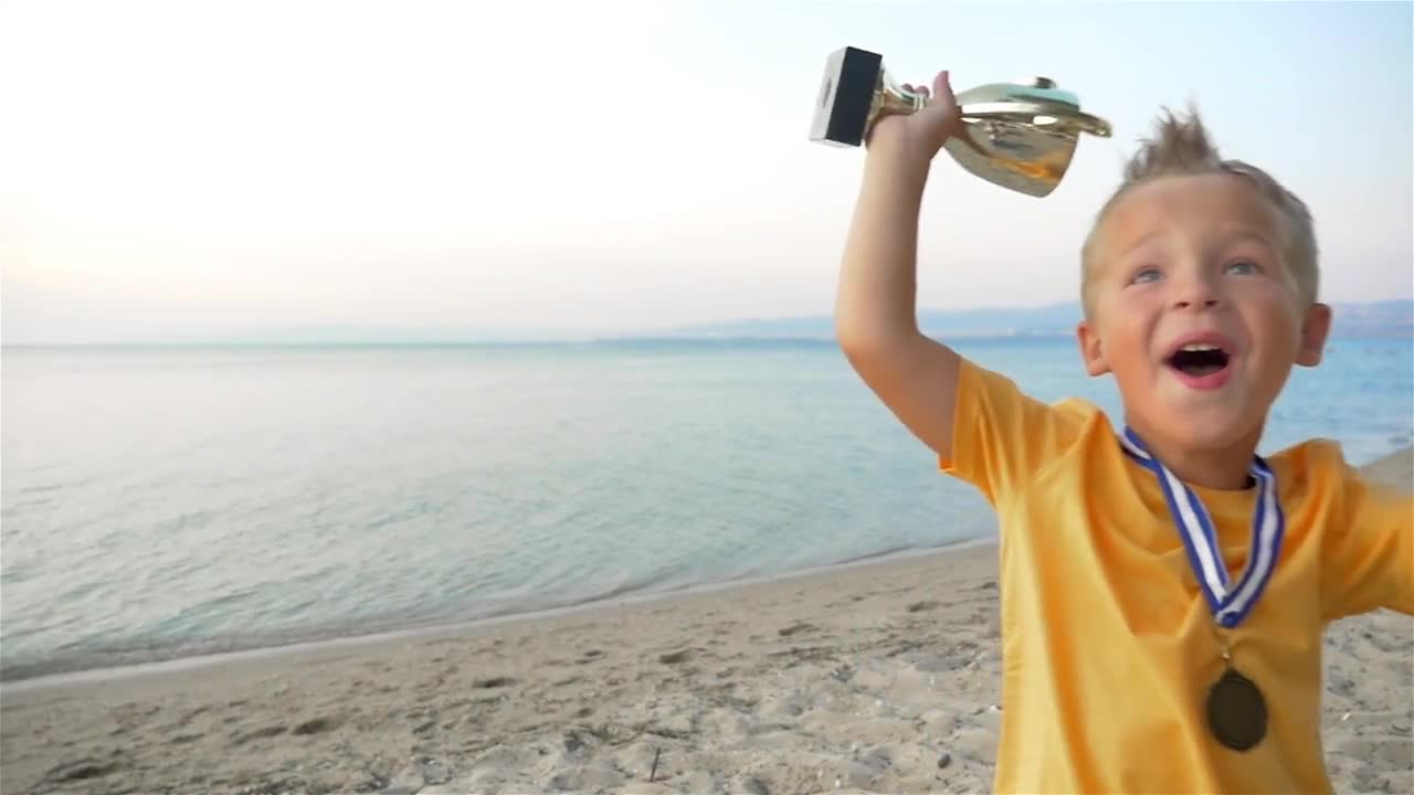 Boy Celebrates With Trophy - Stock Video | Motion Array