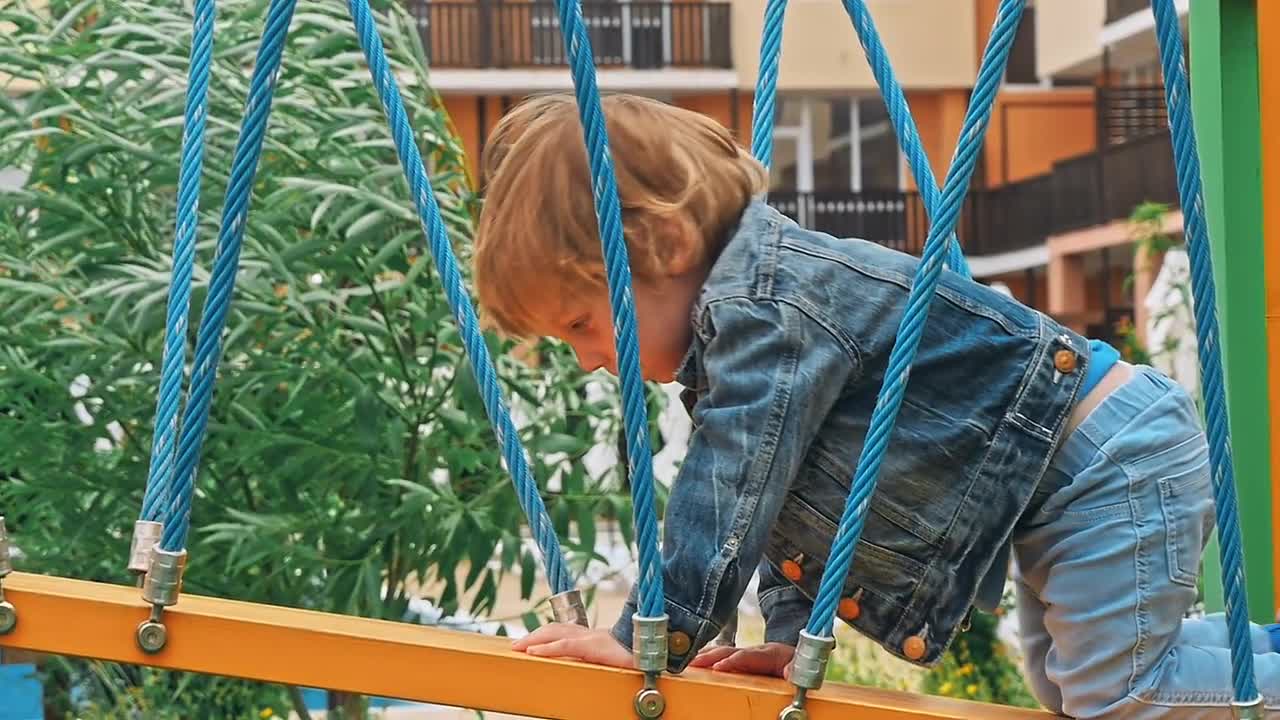 Boy Crawling On Playground Plank - Stock Video | Motion Array