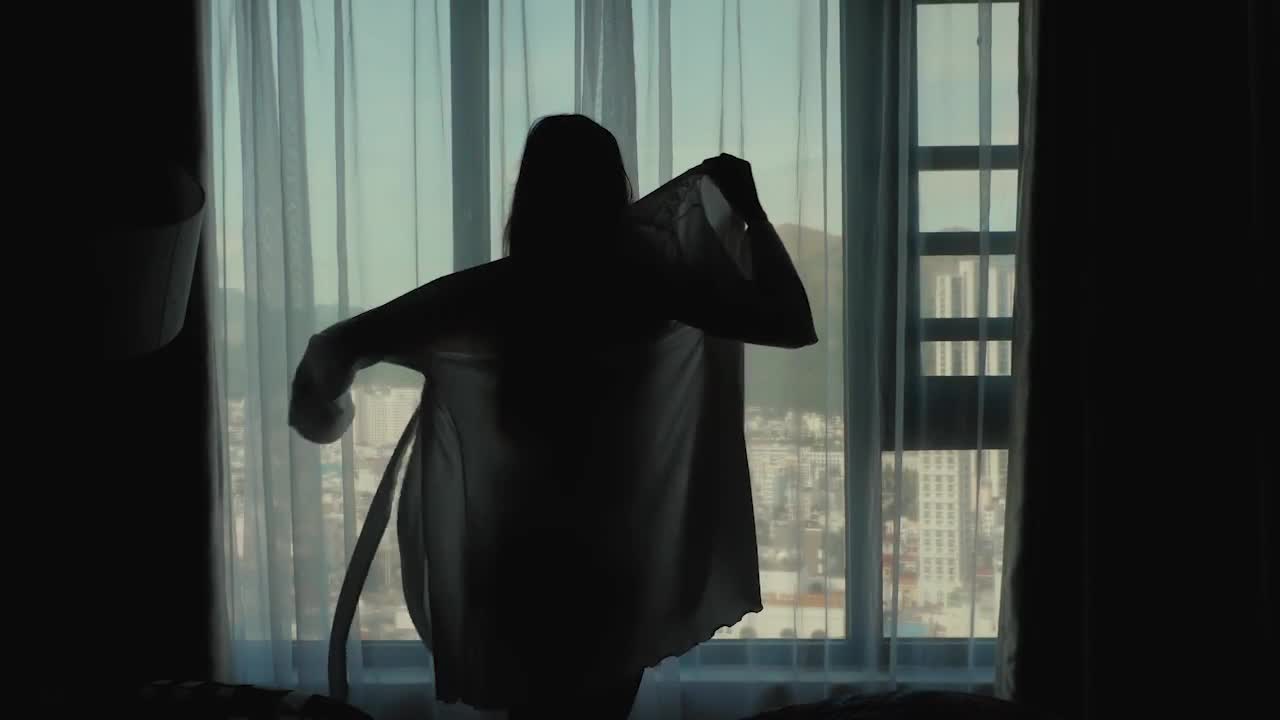 Woman Dressing By Window - Stock Video | Motion Array
