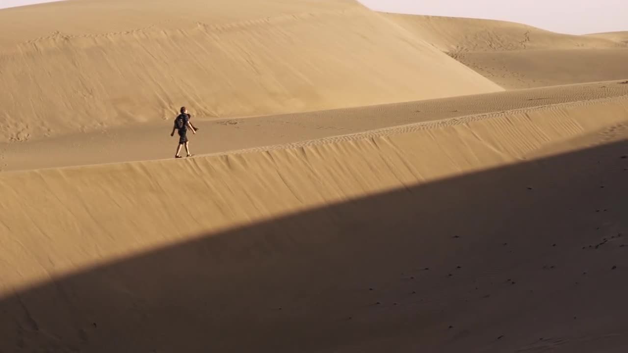 Walking Along Sunlit Sand Dune - Stock Video | Motion Array