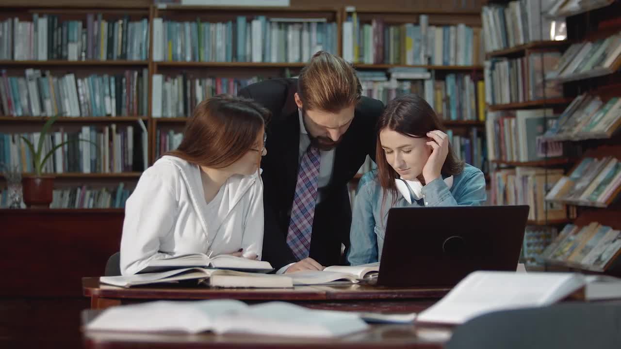 Professor Talks With Students In Library - Stock Video | Motion Array