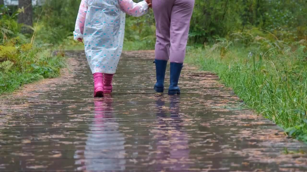 Mother And Daughter Walking In The Rain - Stock Video | Motion Array
